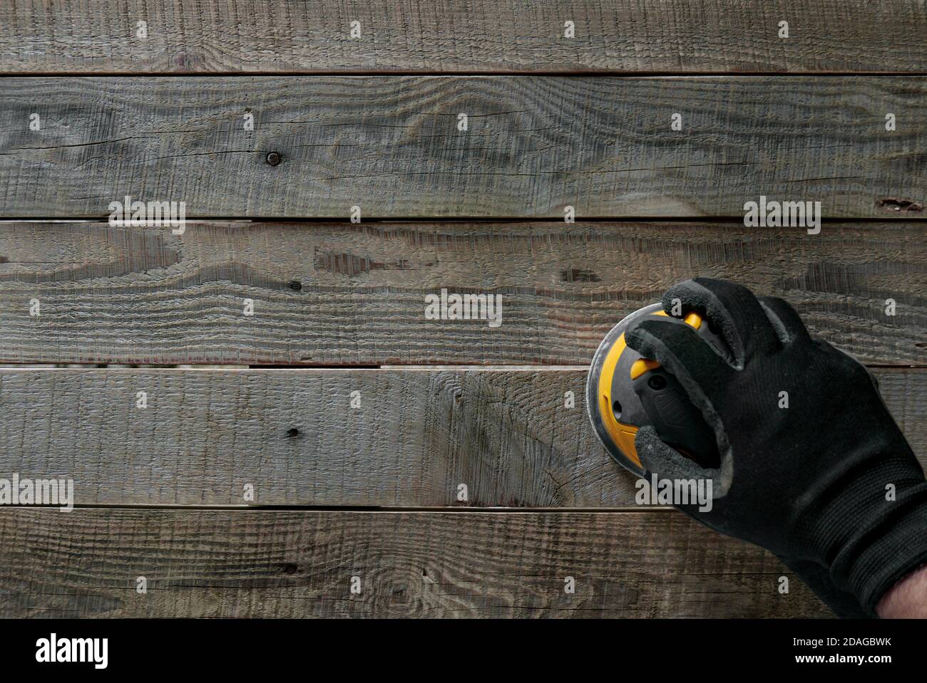 Top view of hand with protective glove holding equipment over a wooden ...