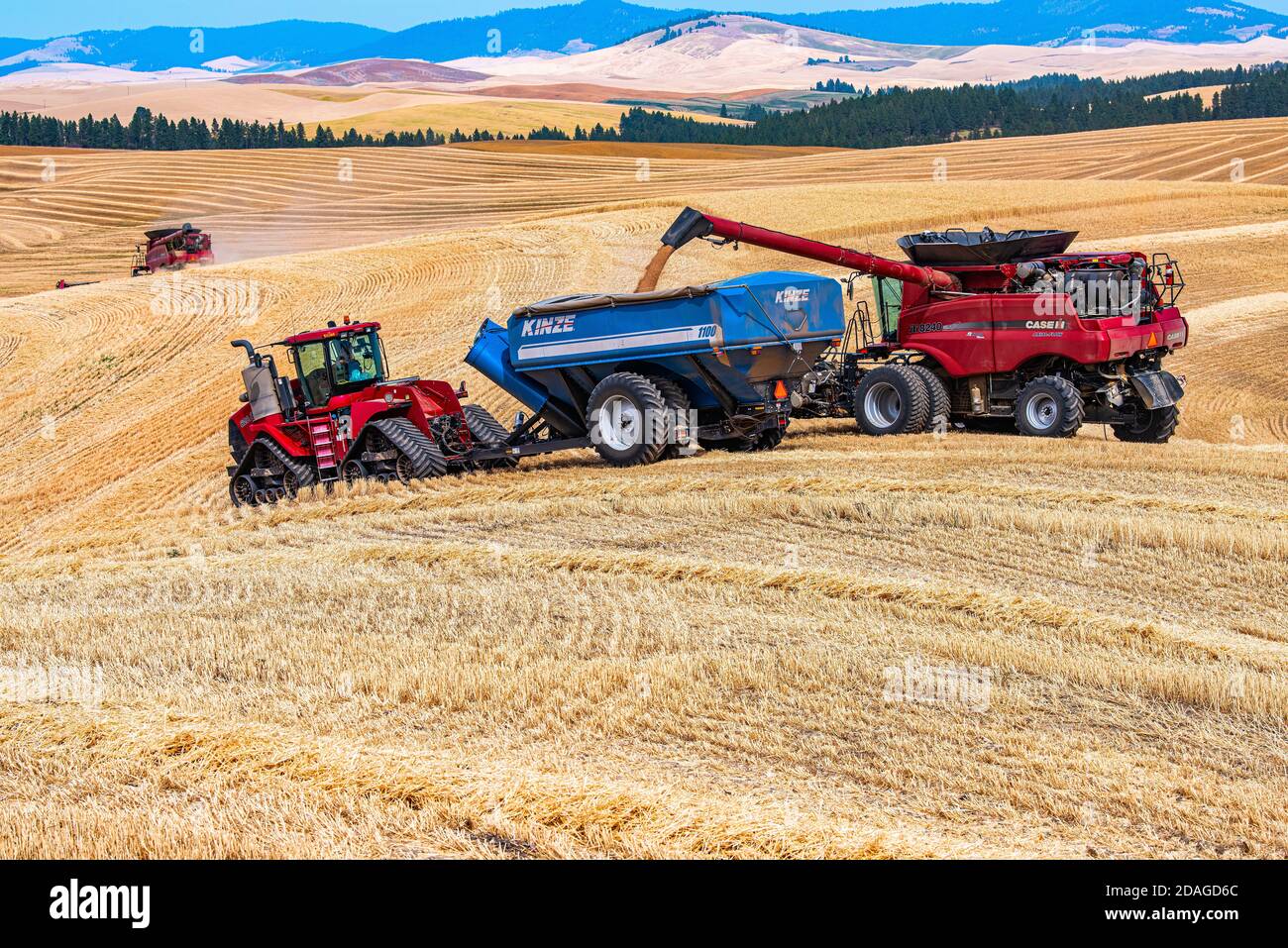 CaseIH combine offloading grain to Kinze grain cart pulled by a ...