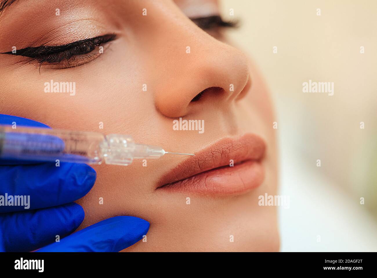 Attractive young woman gets cosmetic injection, isolated over black ...