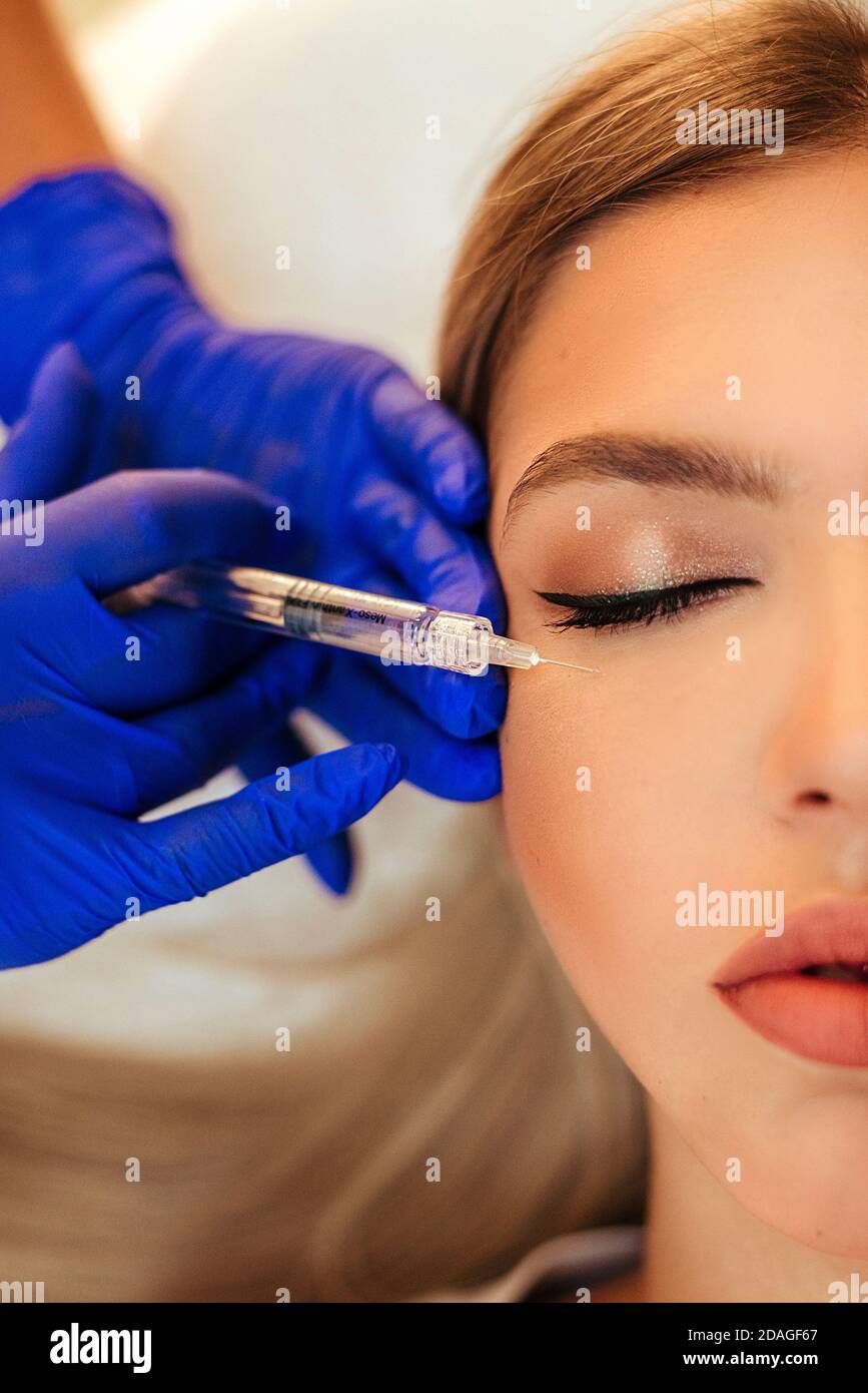 Beautiful woman gets an injection in her face. she has fashion make up ...