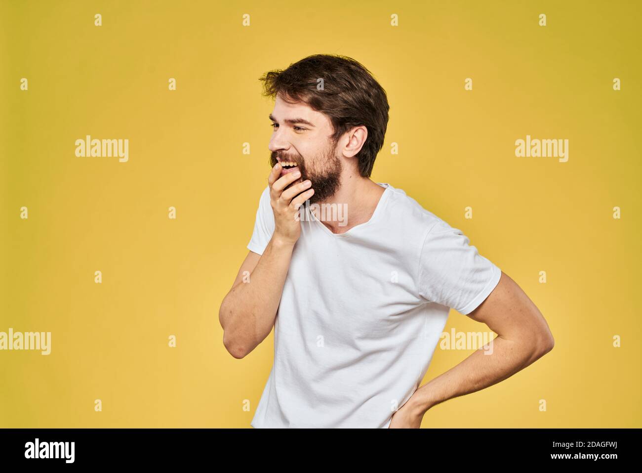 Man gesturing with hands emotions lifestyle white t-shirt yellow isolated background Stock Photo ...