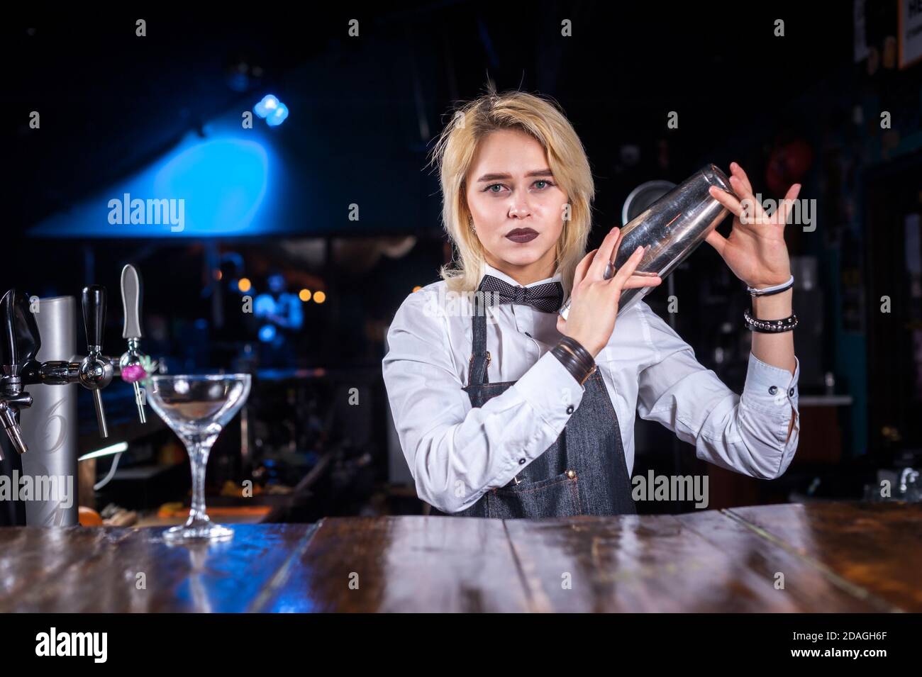 Pretty woman bartending demonstrates his skills over the counter while ...