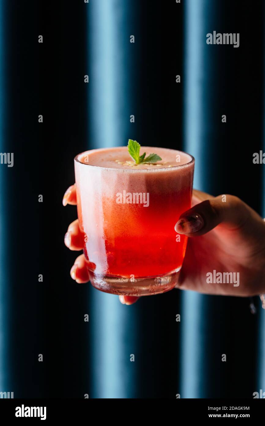 red strawberry alcoholic cocktail in a woman's hand Stock Photo - Alamy