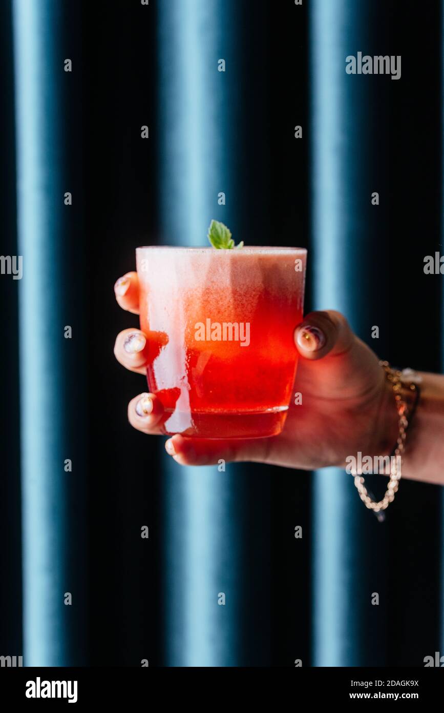 red strawberry alcoholic cocktail in a woman's hand Stock Photo - Alamy