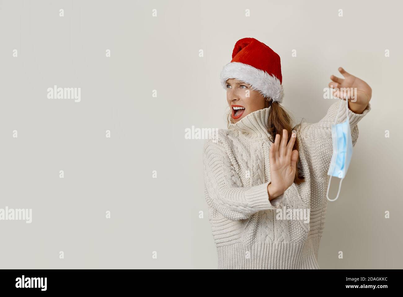 Woman wearing a Santa hat removing the protective mask Stock Photo - Alamy