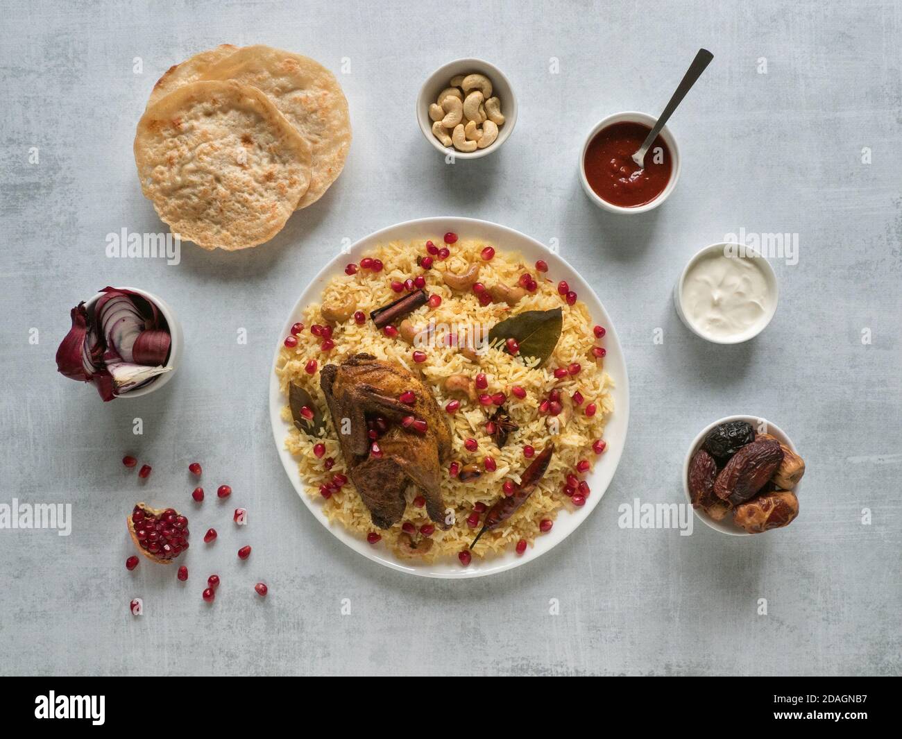 Chicken Mandi with dates on a light table. Arabic cuisine. Top view ...