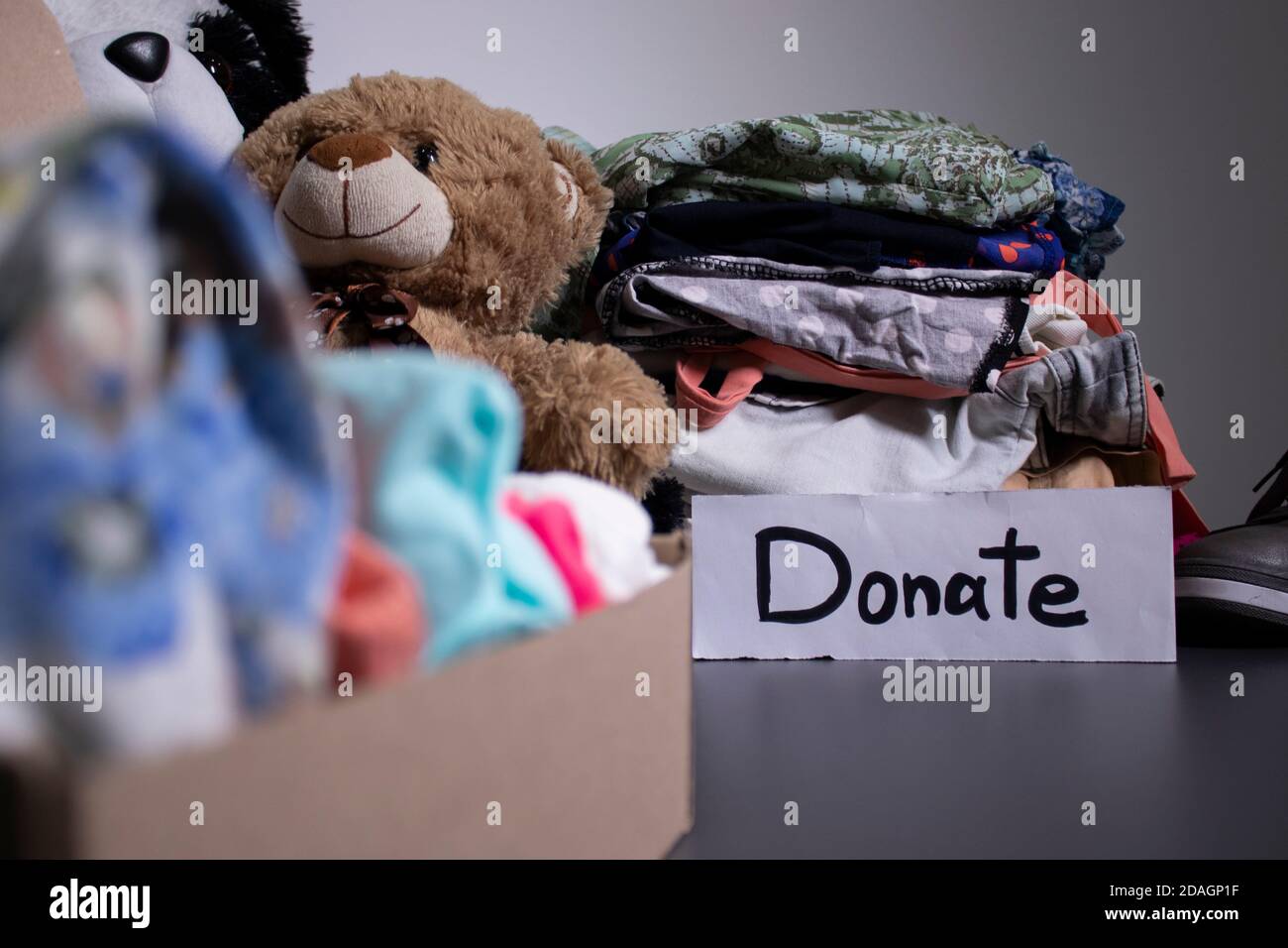 'Donate' sign handwritten with black letters. A box with clothes and a ...