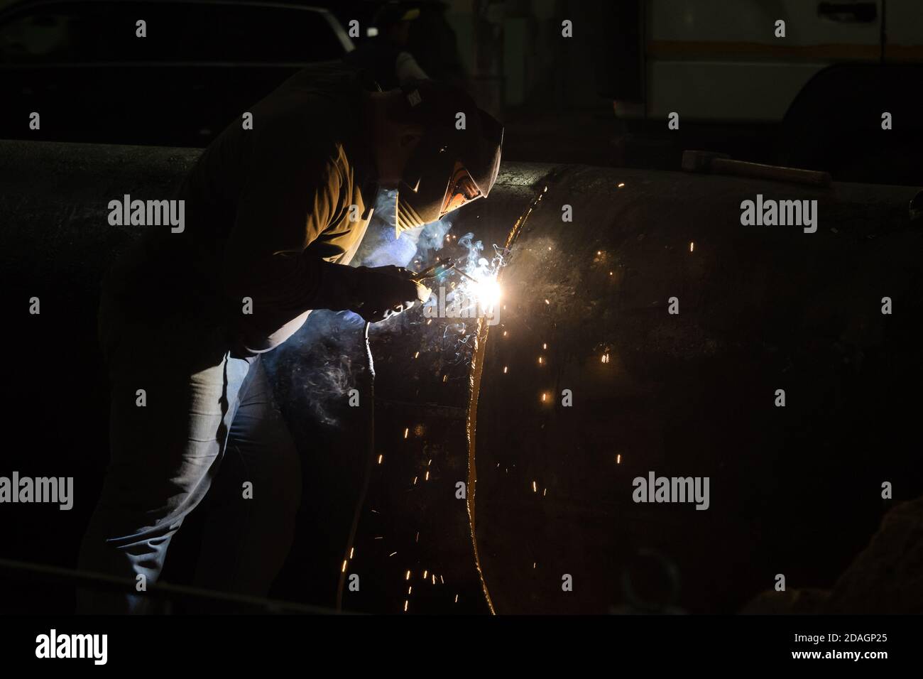 Professional mask protected welder man working on metal welding and ...