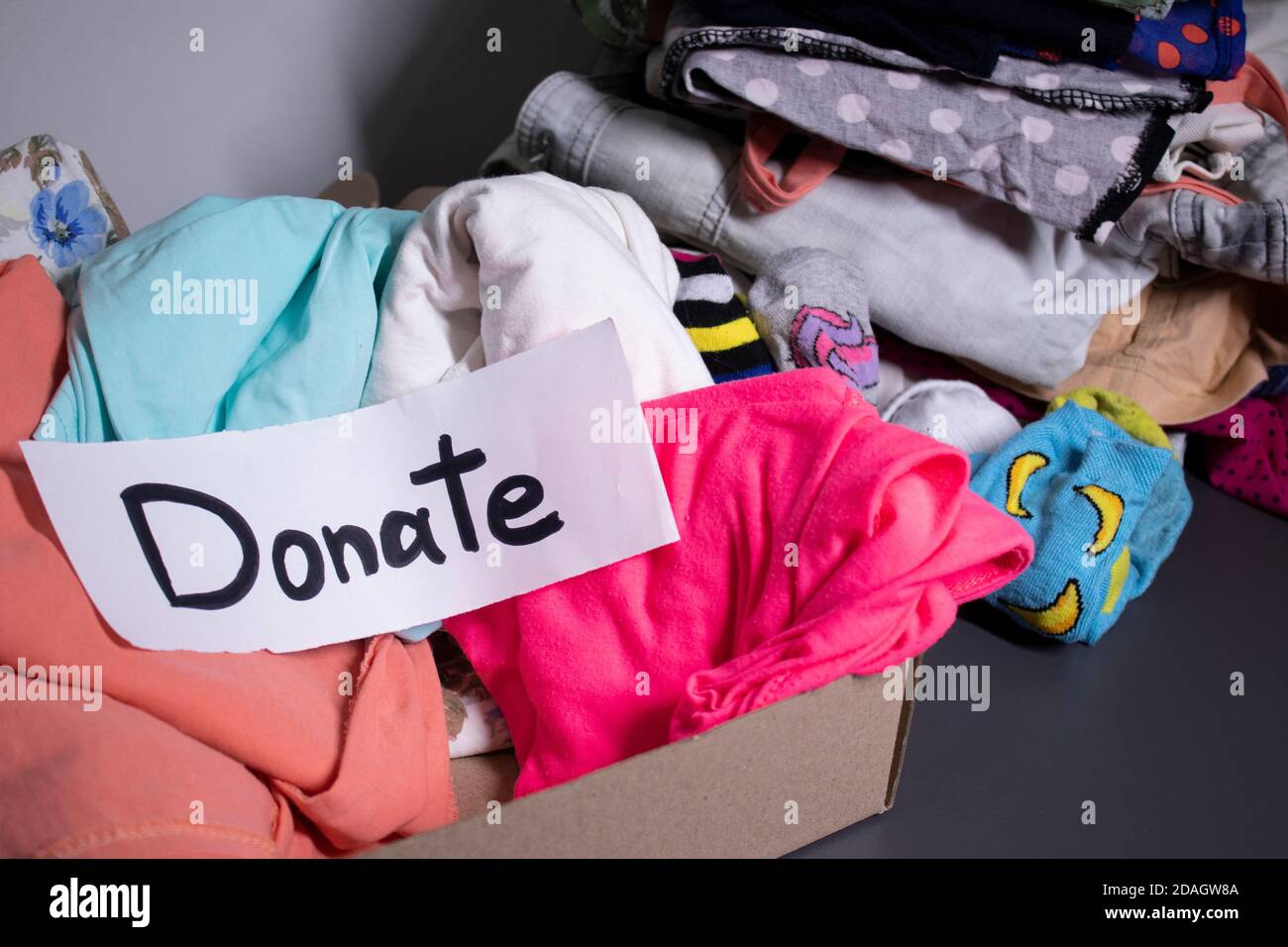 'Donate' sign handwritten with black letters. A box with clothes and a ...