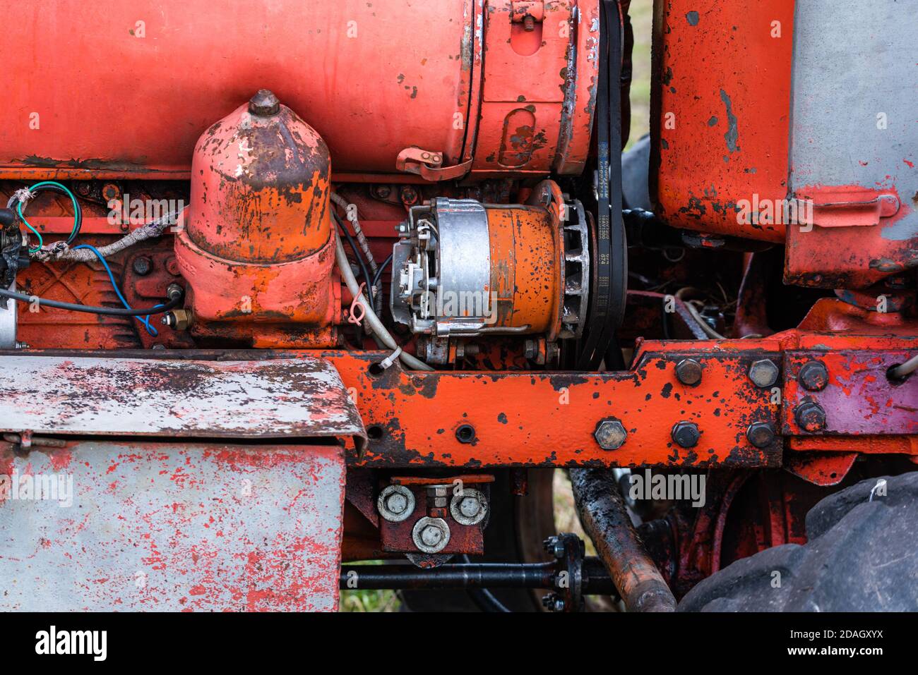 Closeup of four cylinder diesel tractor engine with visible belt rusty ...