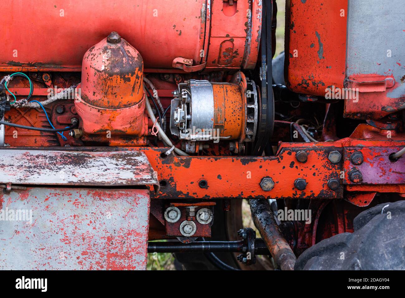 Closeup of four cylinder diesel tractor engine with visible belt rusty ...
