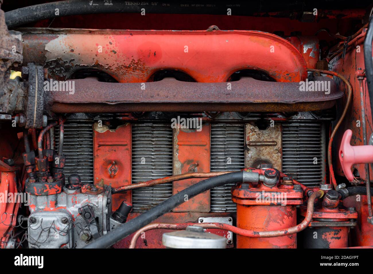 Closeup side view of old tractor engine red rusty vintage abstract ...