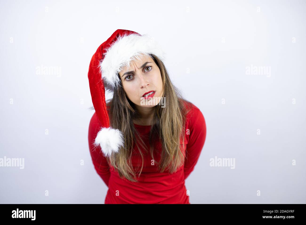 Young beautiful woman wearing a Santa hat over white background afraid ...