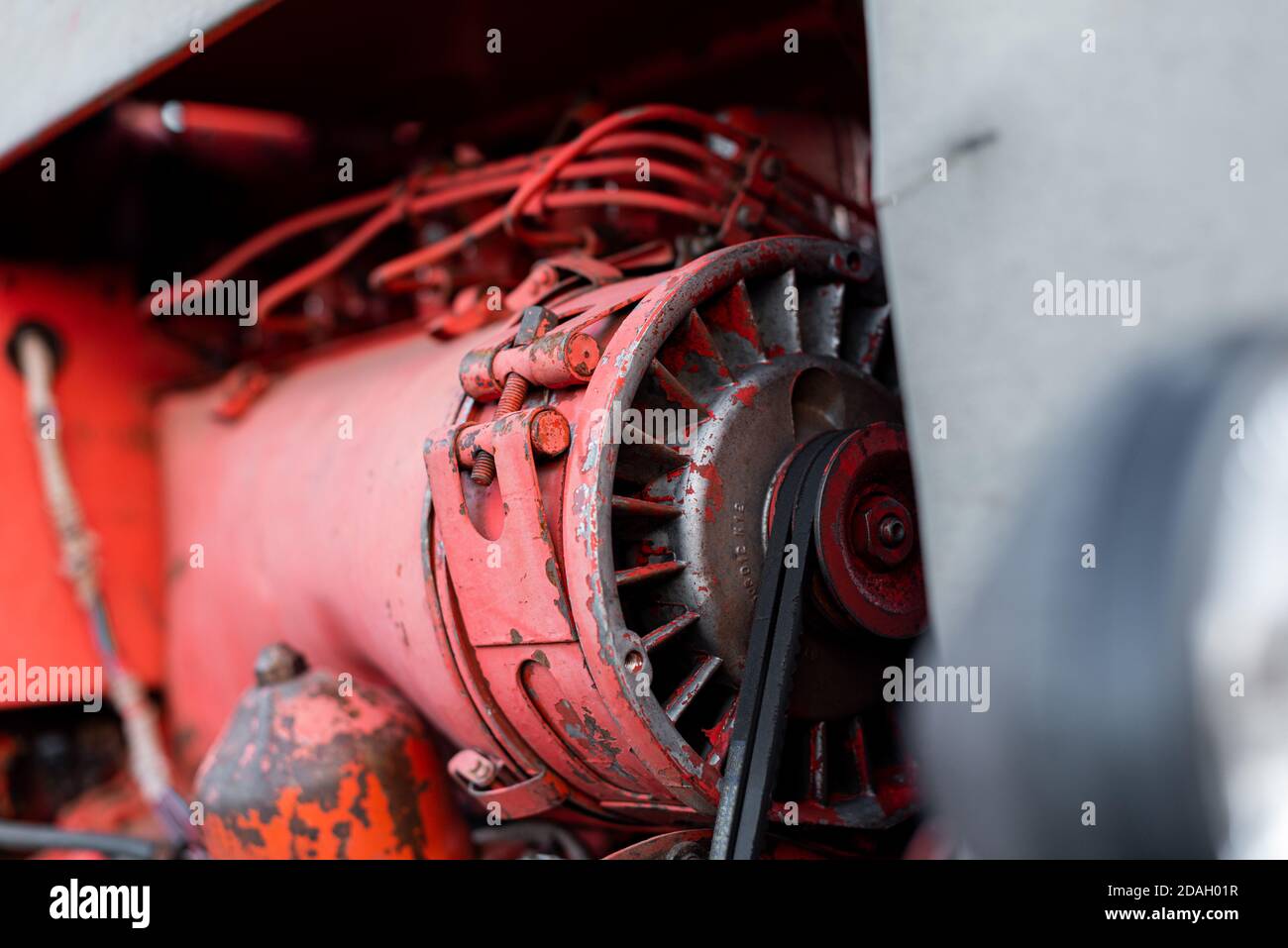 Closeup of four cylinder diesel tractor engine with visible belt rusty ...