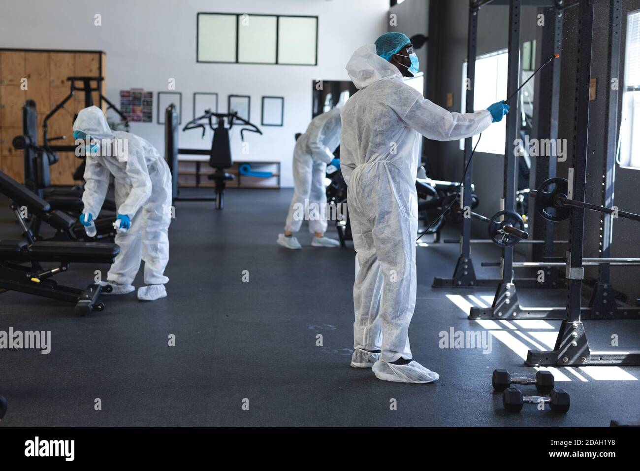 Team of workers wearing protective clothes and face masks cleaning the ...