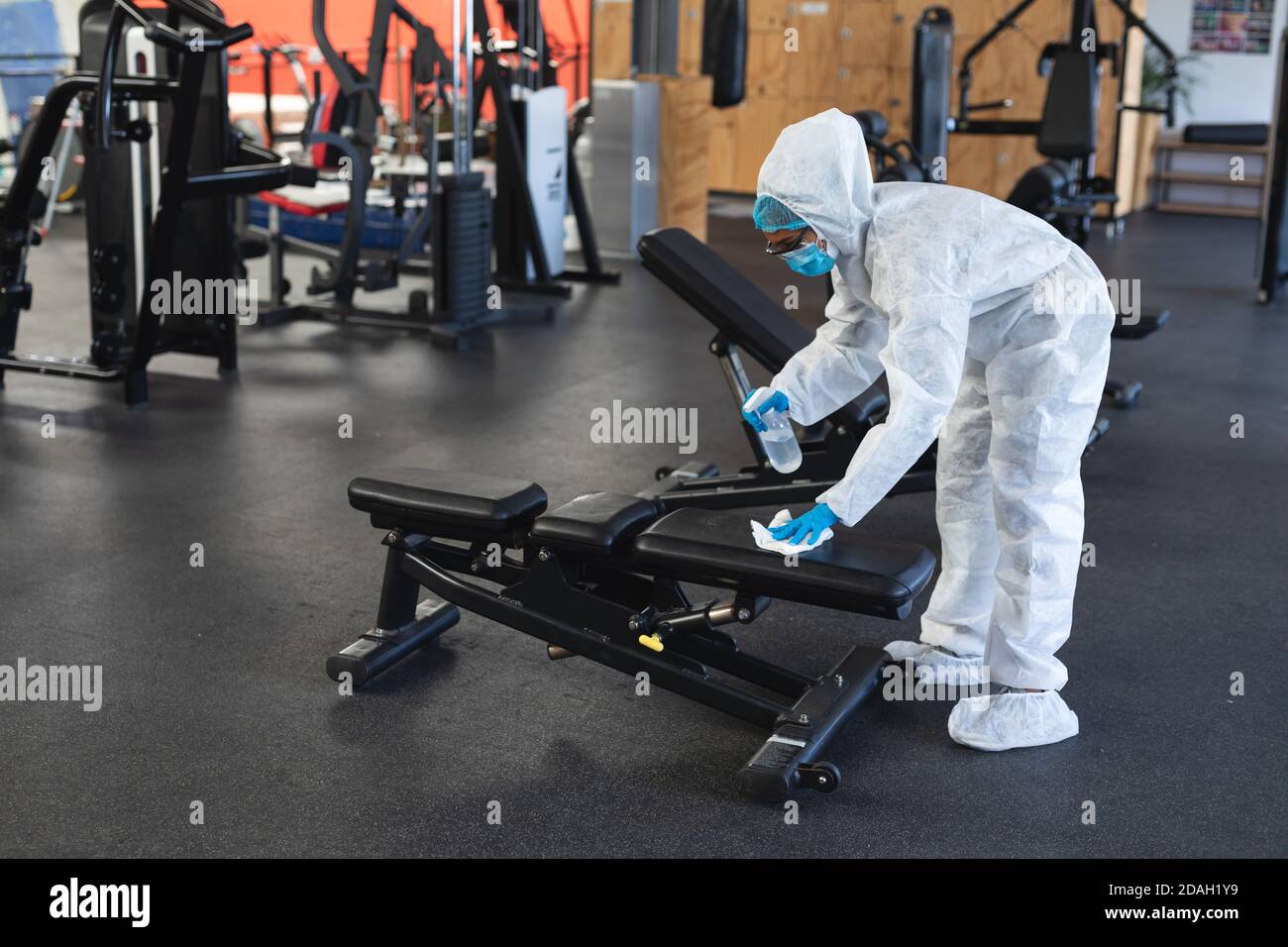 Female worker wearing protective clothes and face masks cleaning the ...