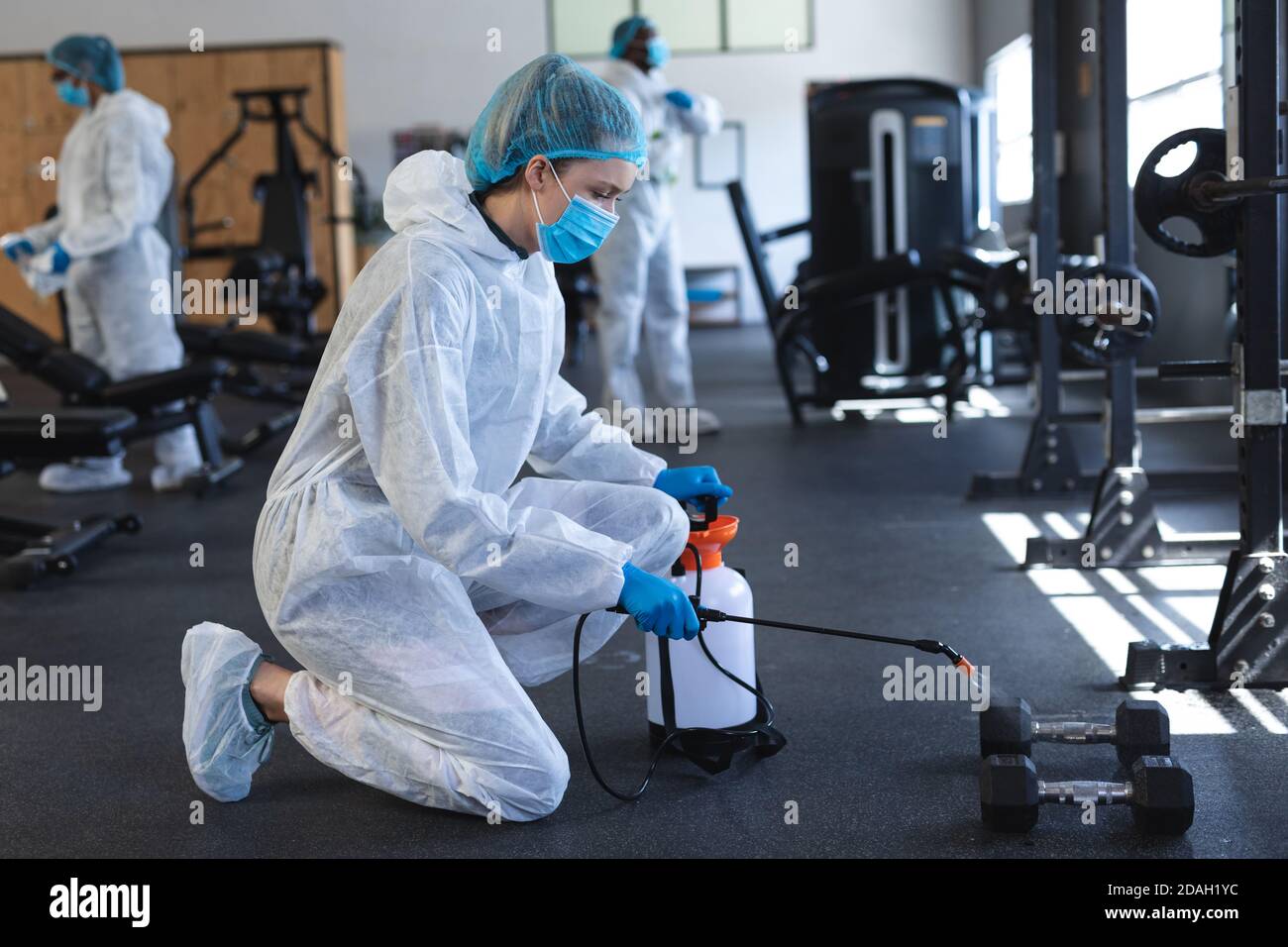 Female worker wearing protective clothes and face masks cleaning the ...