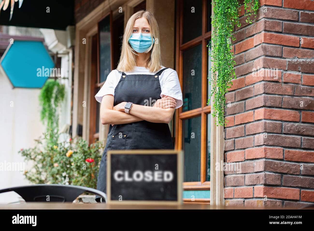 Caucasian waitress woman wearing medical mask and SORRY WE'RE CLOSED ...