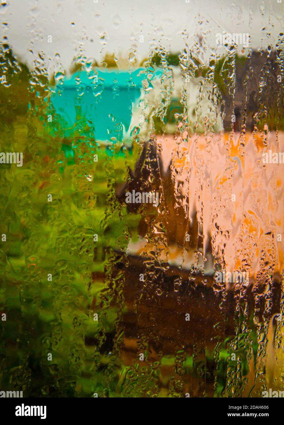 View through glass of country garden houses through window glass ...