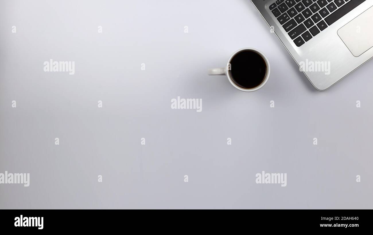 Desk with laptop and a cup of coffee on white surface. Concept for ...