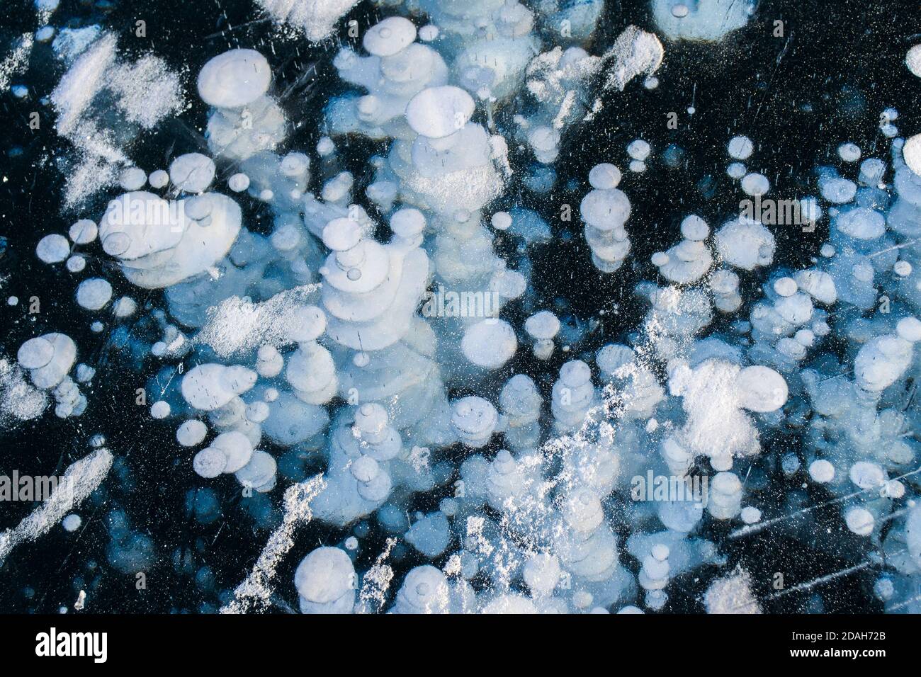 Beautiful transparent blue ice with frozen white methane bubbles ...