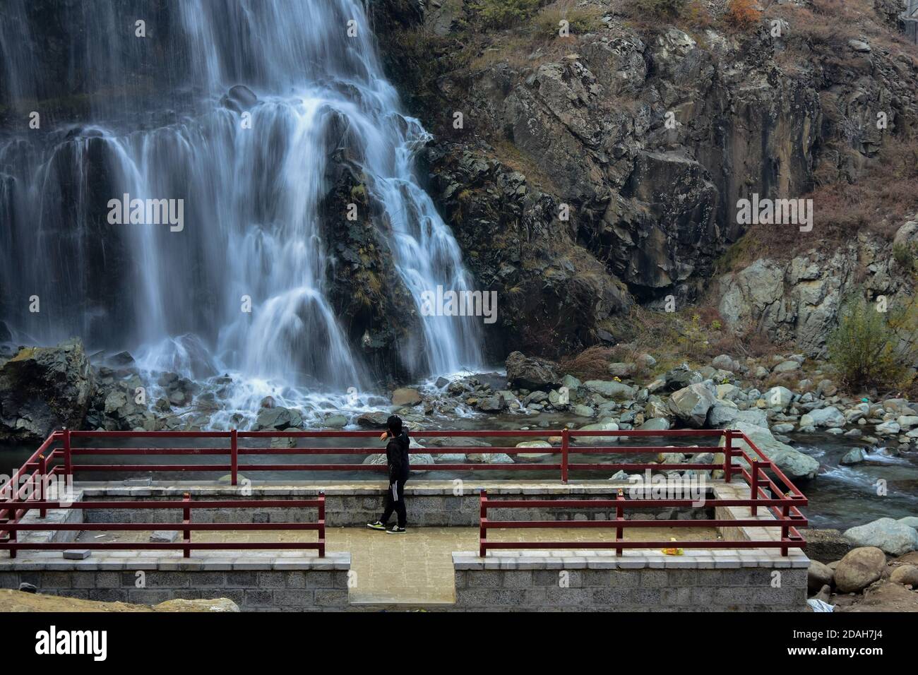 Kashmir, India. 12th Nov, 2020. A visitor explores the waterfalls on an ...