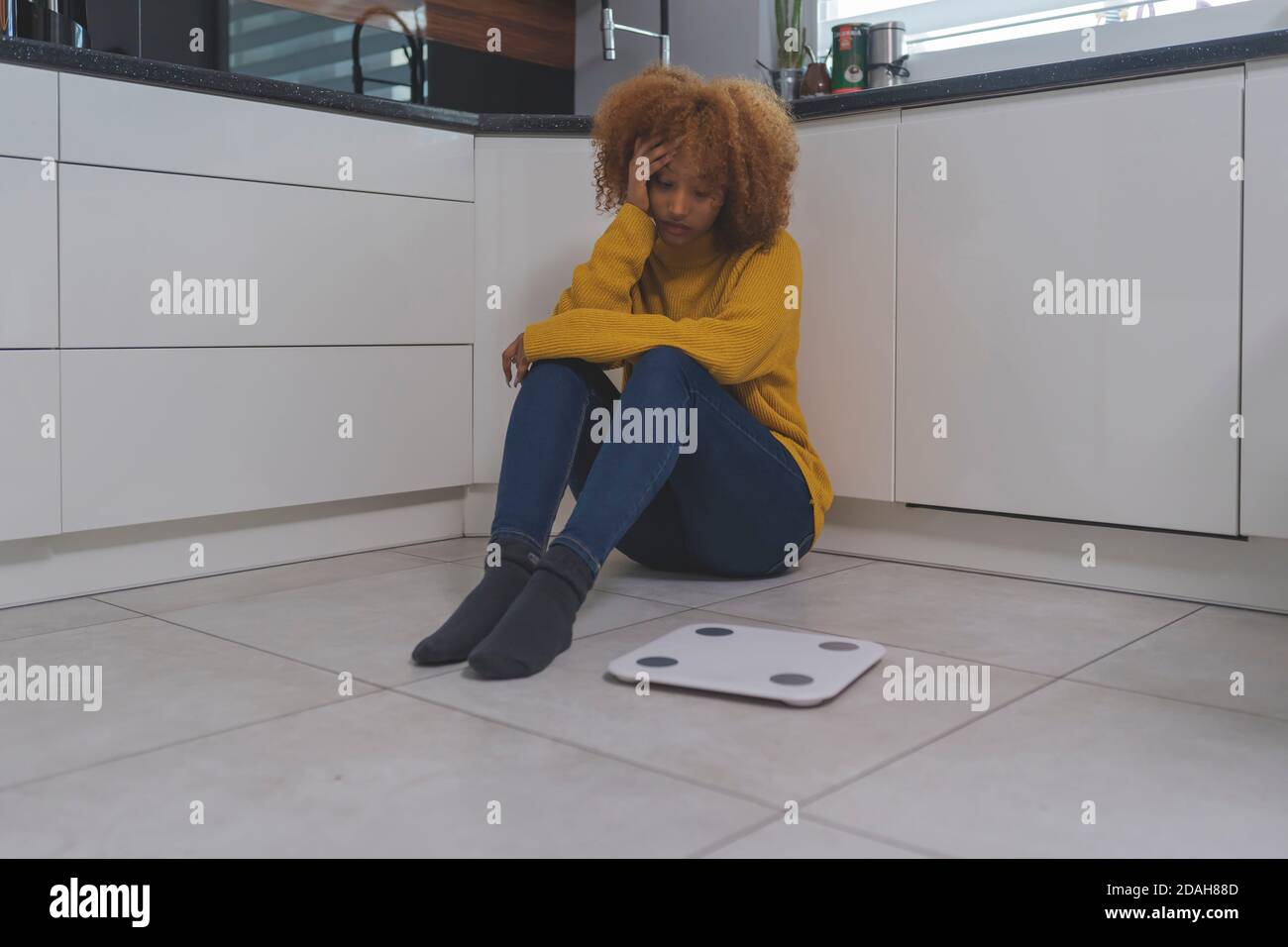 Devastated young african american black woman sitting on the flor with ...