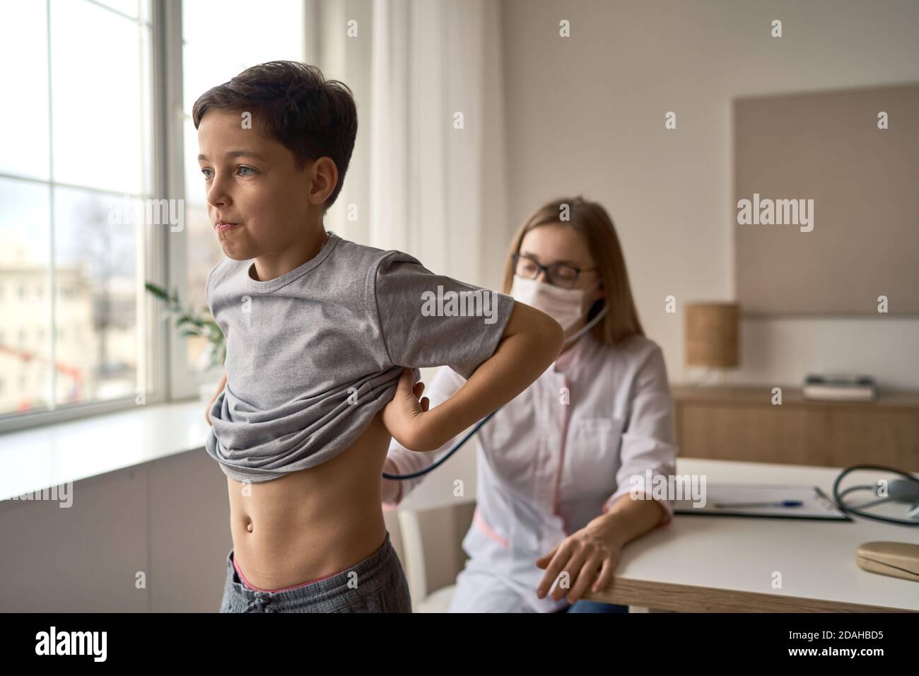Cute boy with pleasure visiting pediatrician, scheduled check up of ...