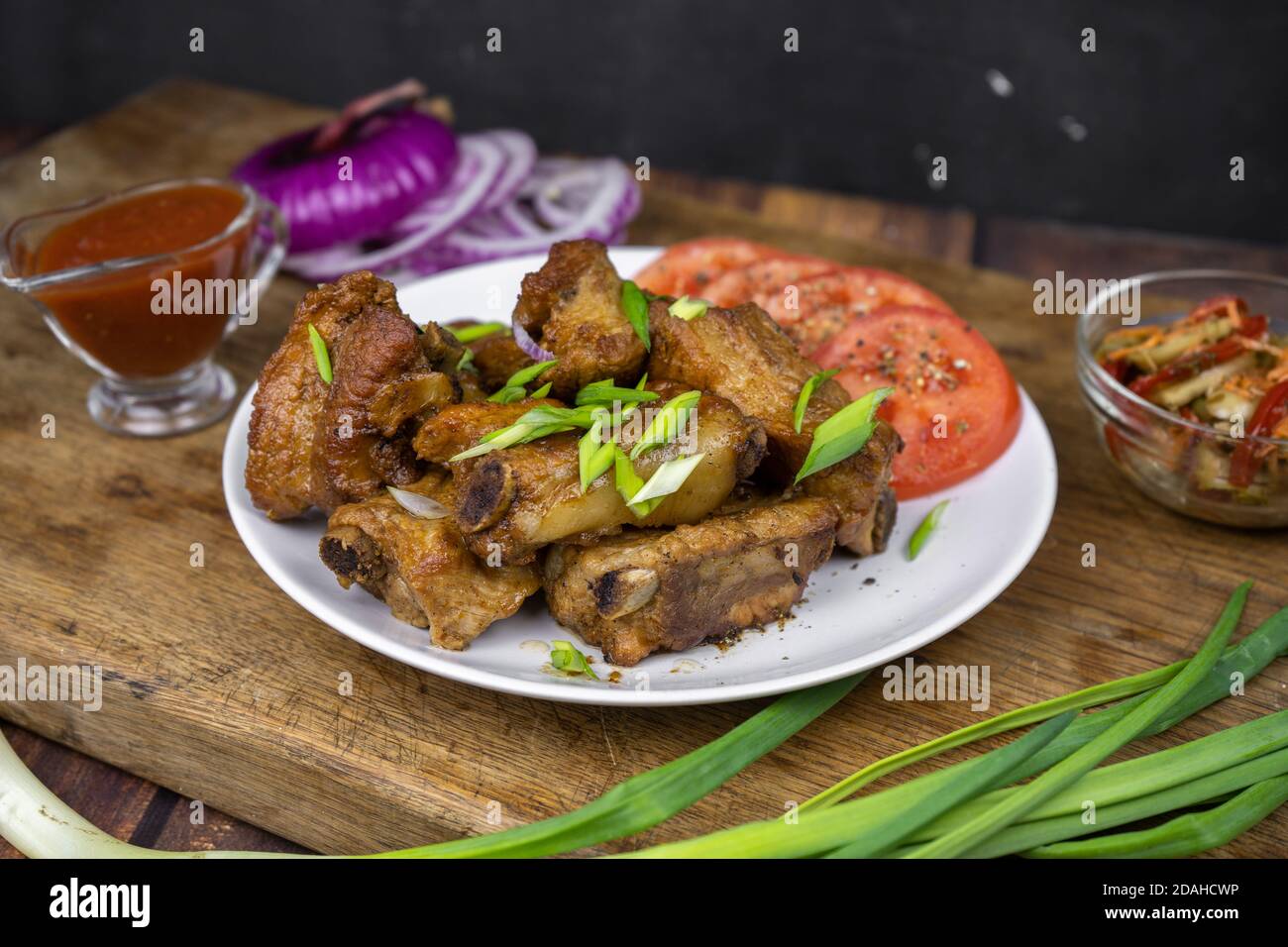 Grilled fat pork ribs on a bone served on a plate with vegetables ...