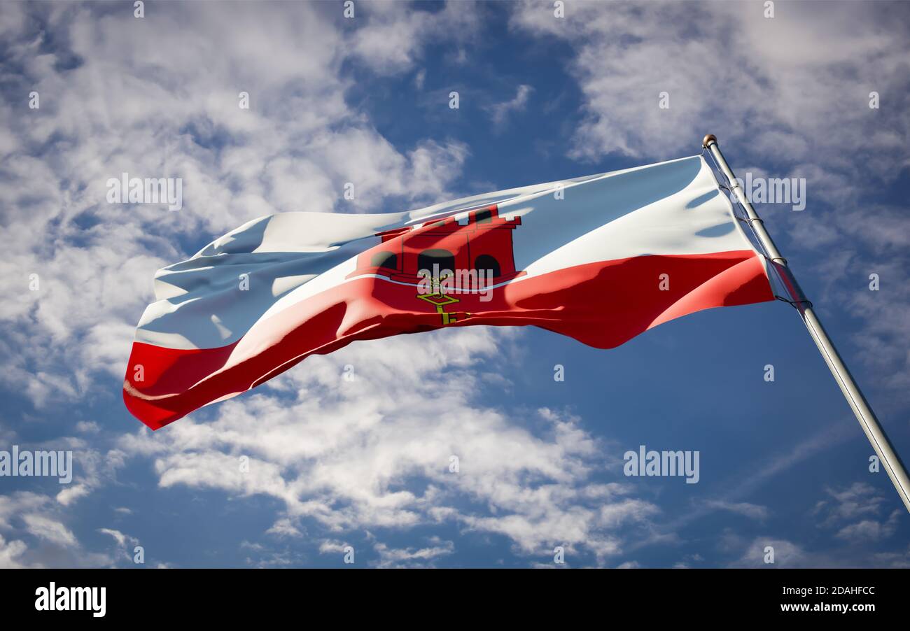 Beautiful national state flag of Gibraltar fluttering at sky background ...