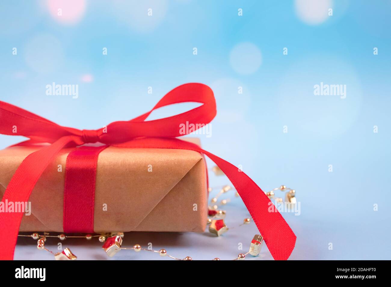 Front view of gift box with red bow on festive blue background with ...