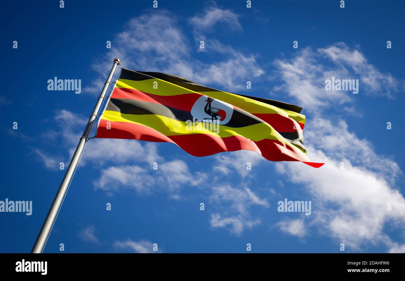Beautiful national state flag of Uganda fluttering at sky background ...