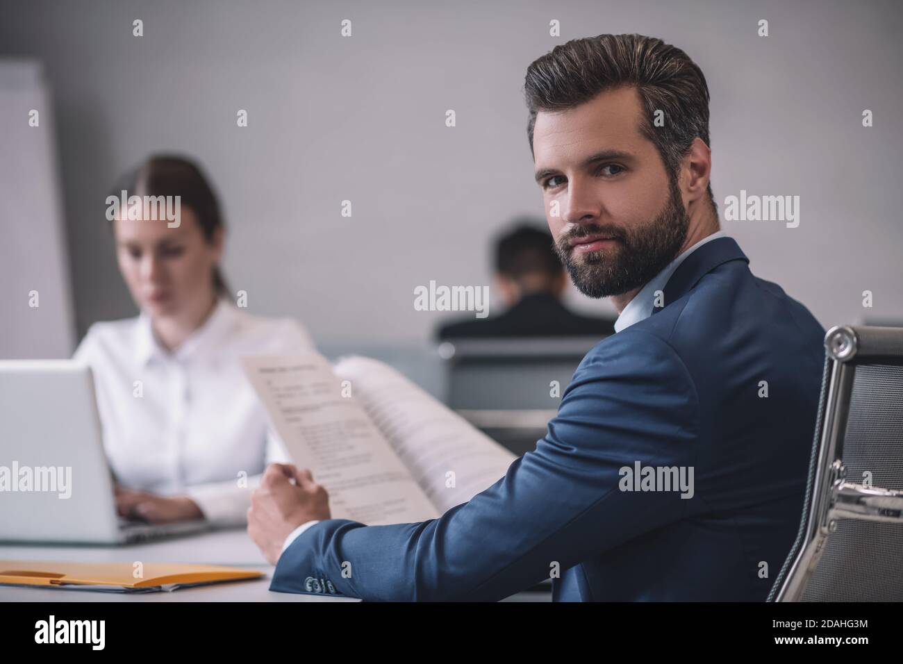 Man looking back and woman behind laptop Stock Photo - Alamy