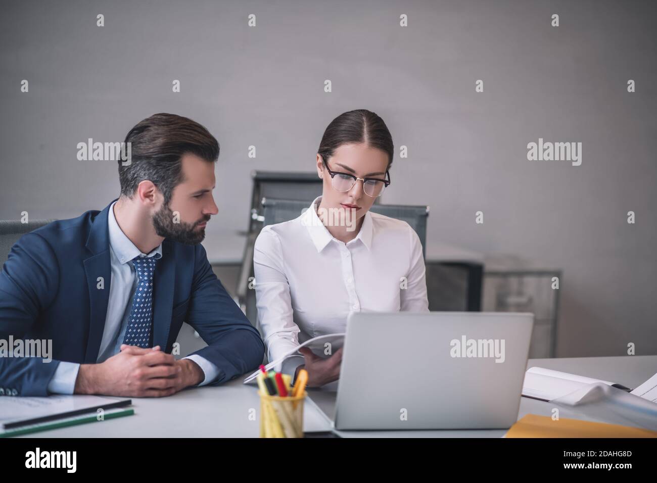 Bearded male and brown-haired female checking something on laptop Stock ...