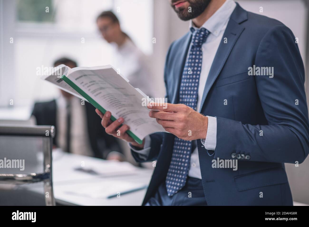 Man in suit studying document, no face visible Stock Photo - Alamy