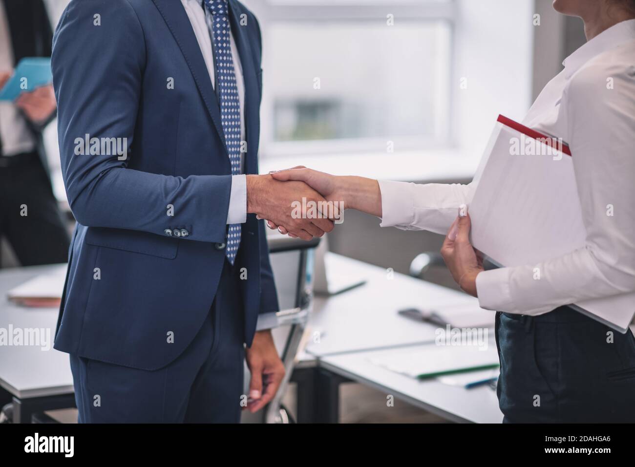 Man and woman with handshake standing in office Stock Photo - Alamy