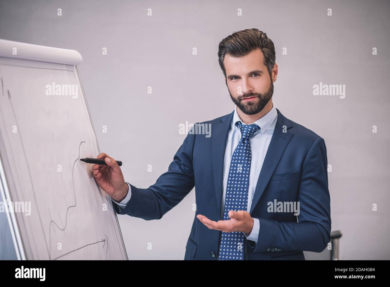 Successful man showing drawn graph at stand Stock Photo - Alamy