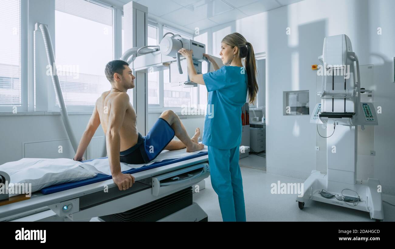 In the Hospital, Man Sitting on a Bed, Female Technician adjusts X-Ray ...