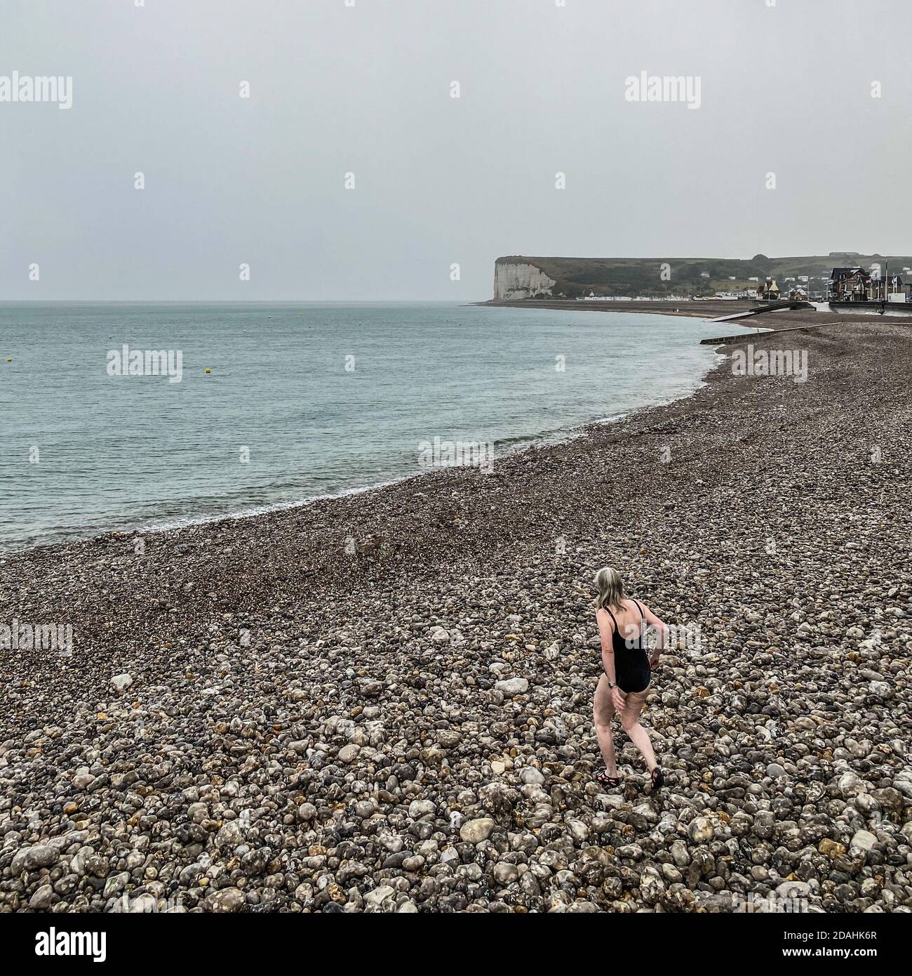 Unrecognizable female swimmer going swimming in the sea in the rain ...