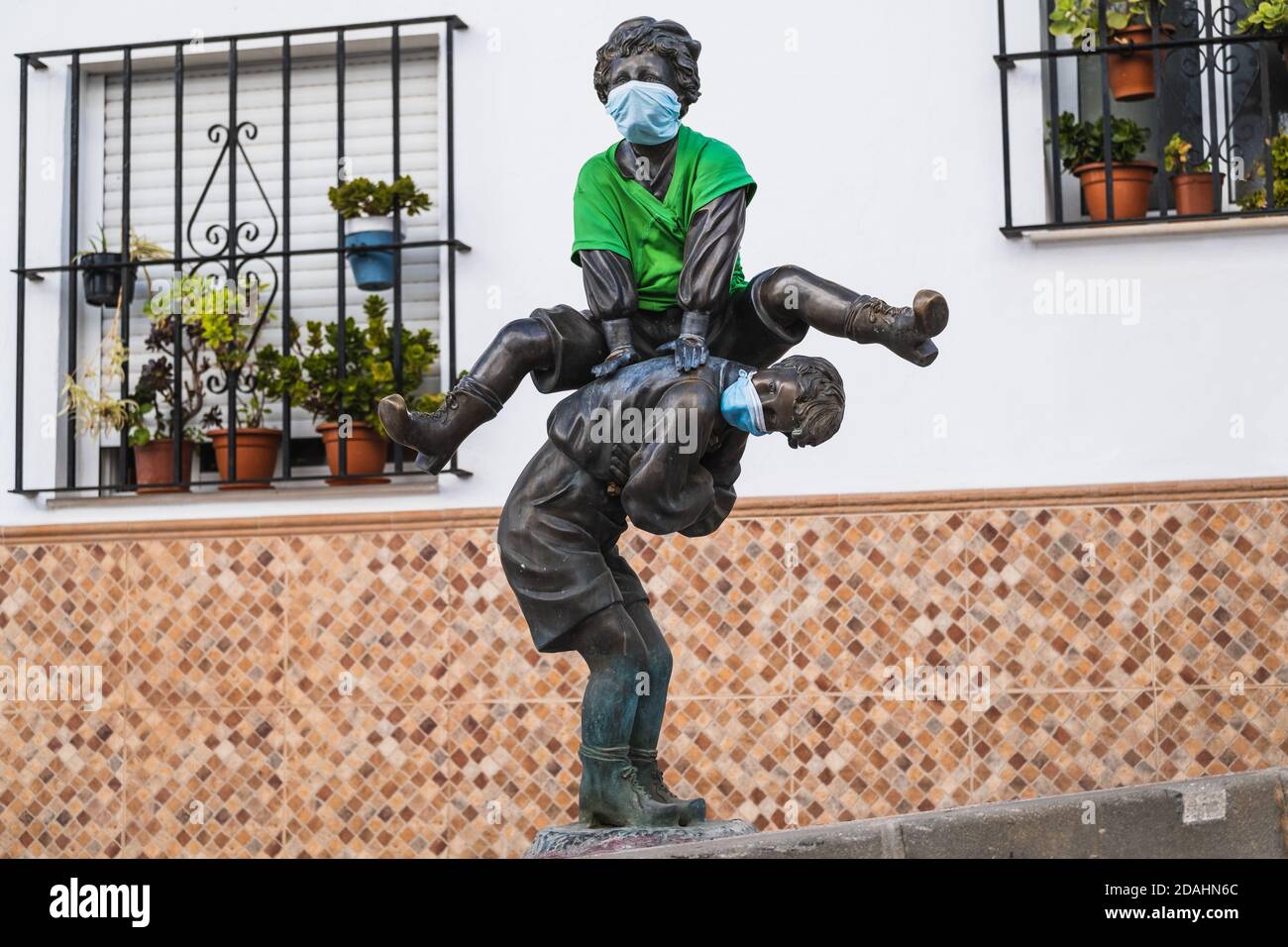 Bronze statues of two children playing in the street jumping on top of ...