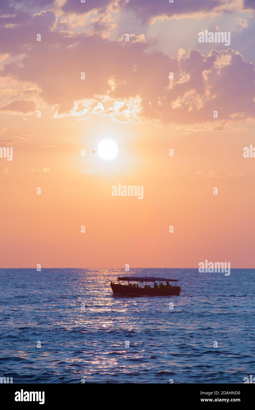 beautiful sunset at sea with vessel at horizon Stock Photo - Alamy