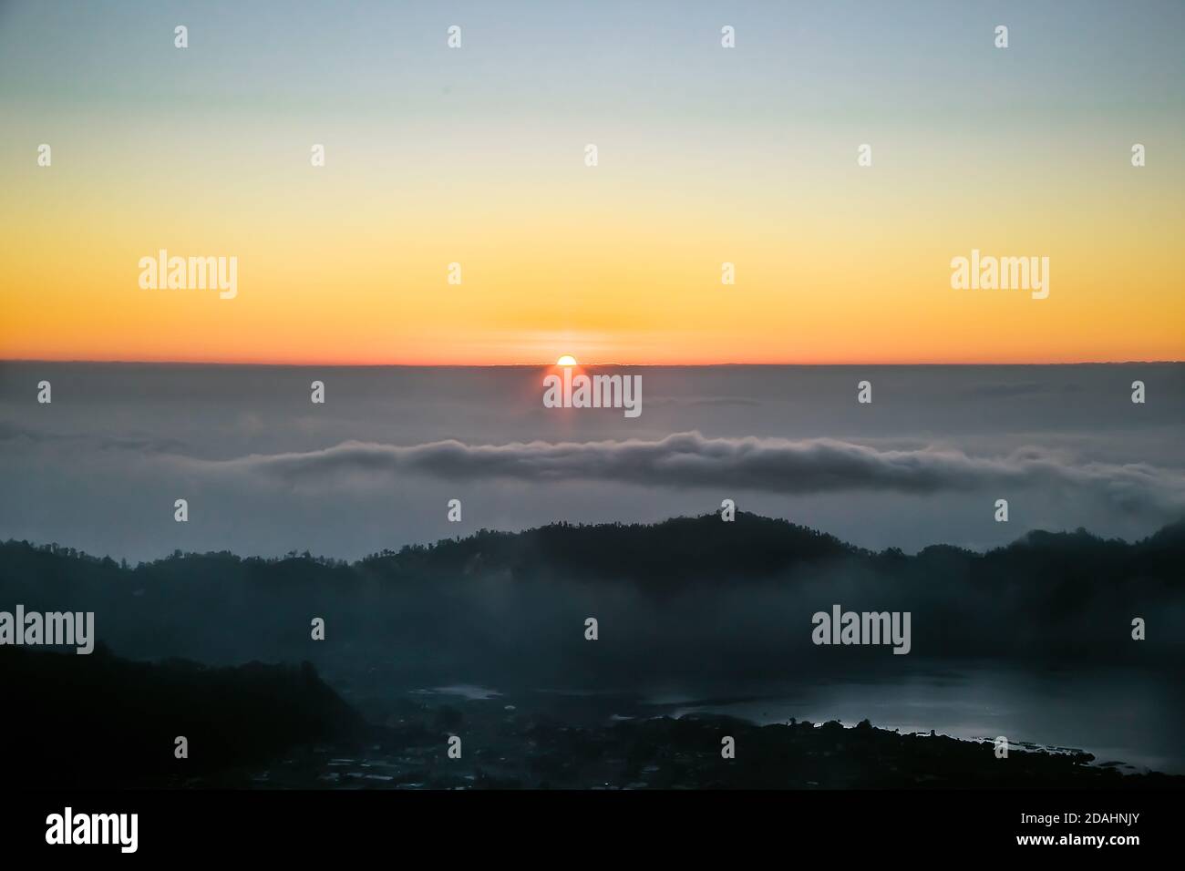 Scenic view by volcano Batur: sun rising over the horizon above a bed ...