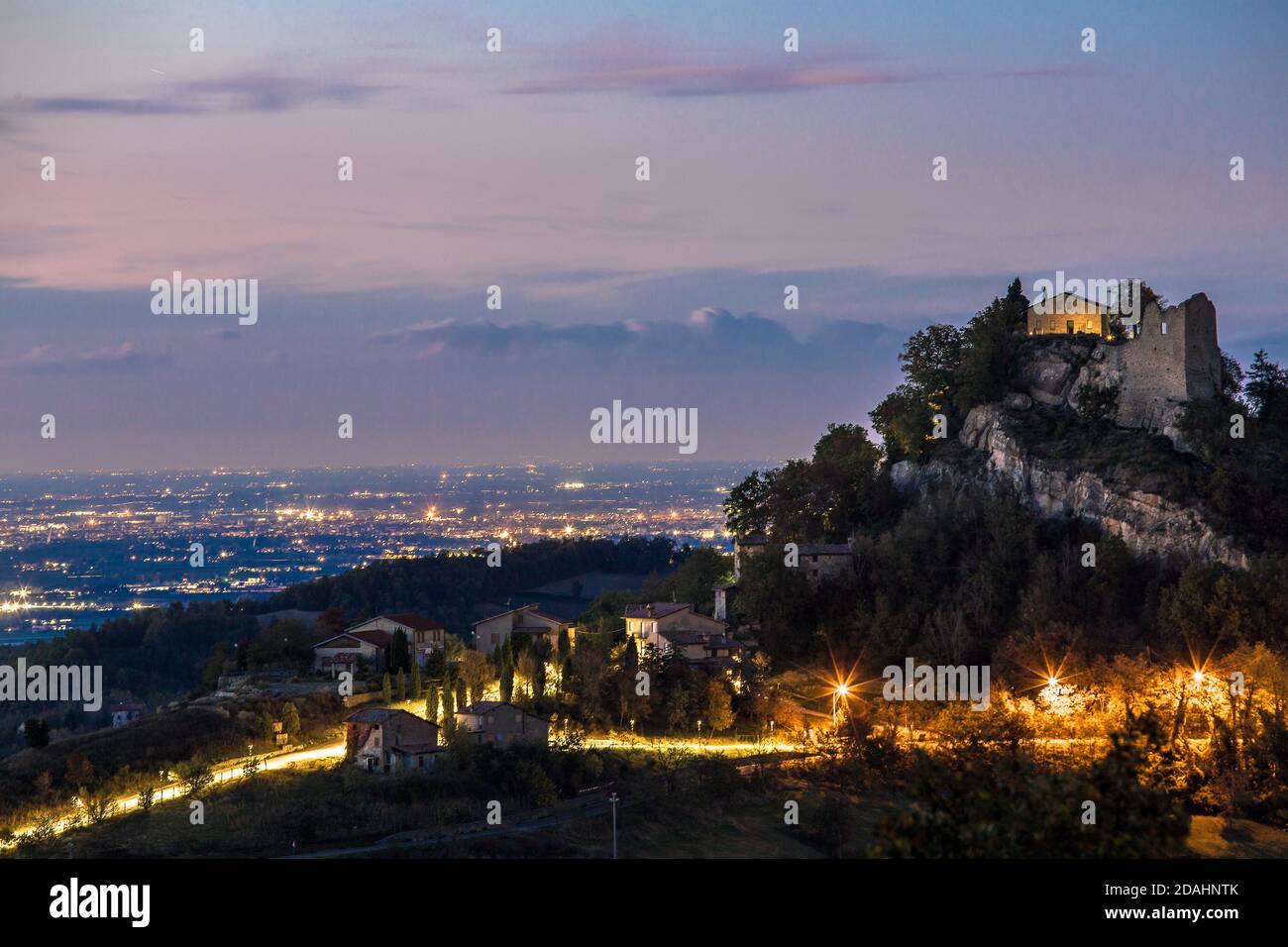 Scenic view of canossa castle, countryside hills and road lights at ...