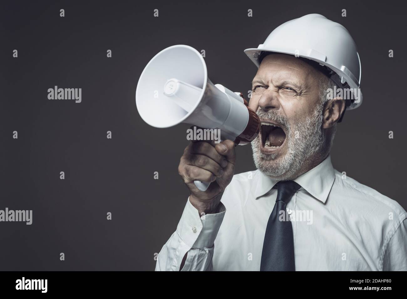 Senior engineer and businessman shouting into a megaphone, marketing ...