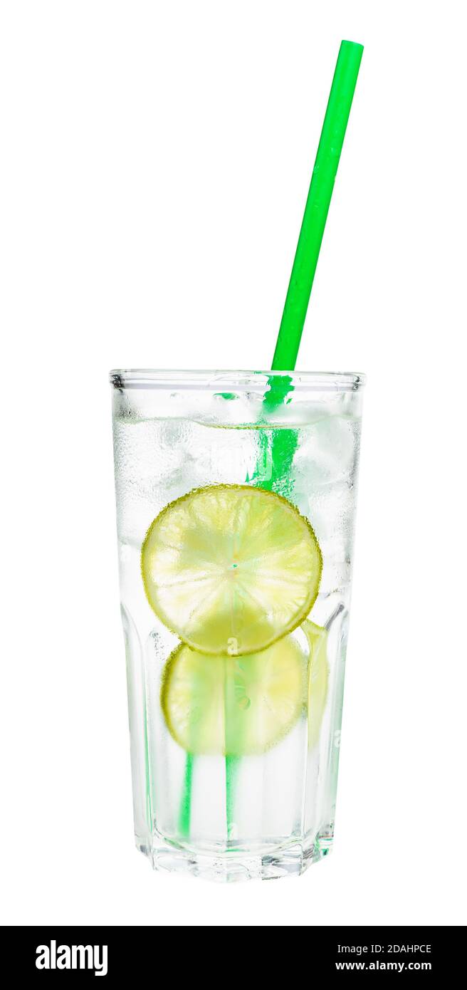 side view of gin and tonic cocktail in highball glass with two slices of lime, ice and green ...