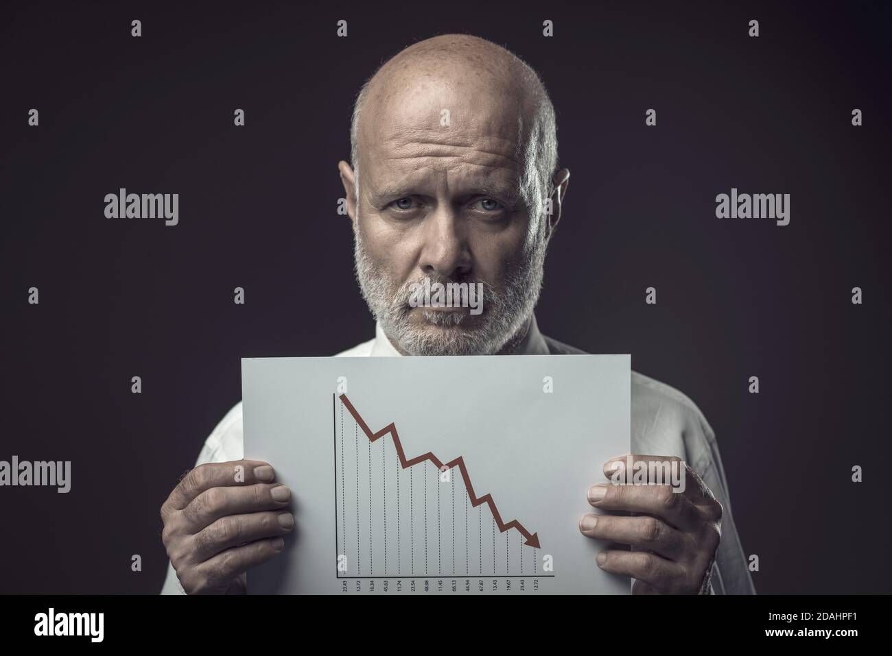 Worried businessman holding a negative financial chart, crisis and ...