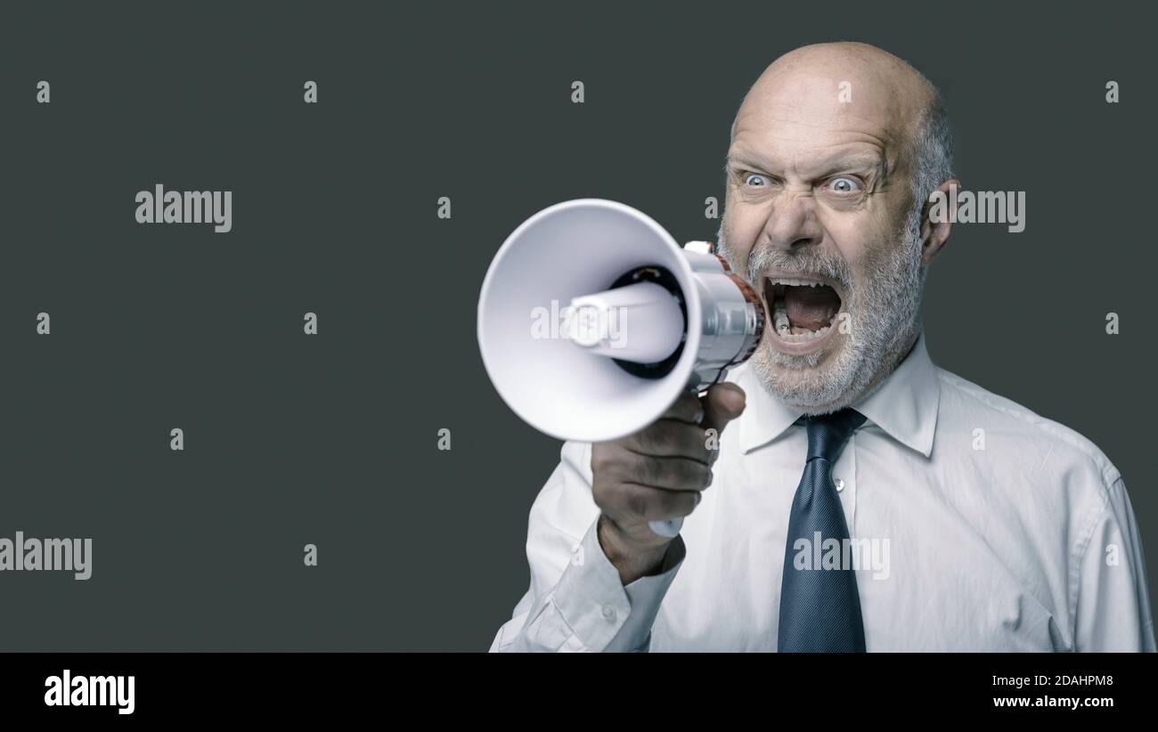 Aggressive senior boss shouting on a megaphone, leadership and ...