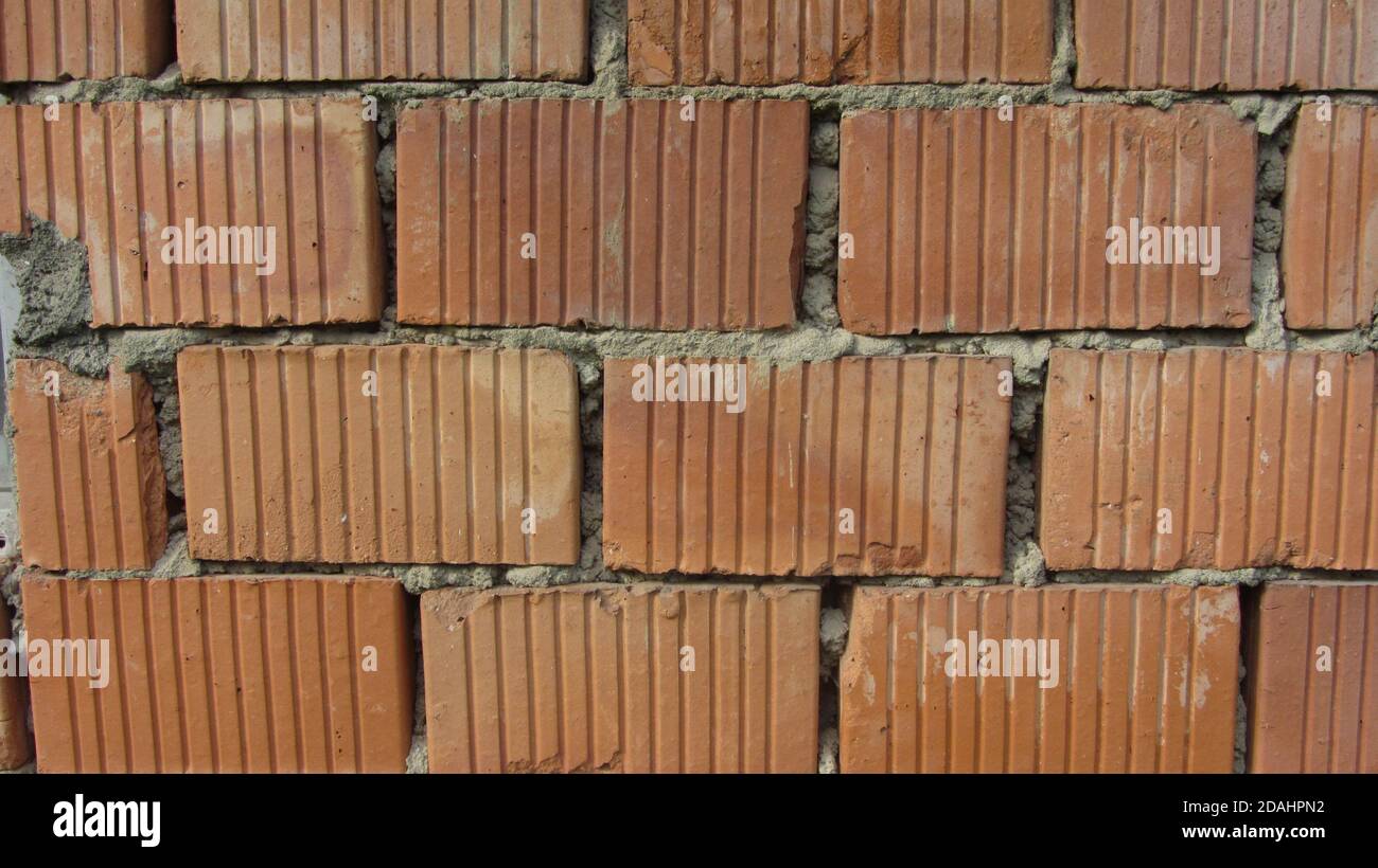 an unplastered red brick wall as part of a building Stock Photo - Alamy