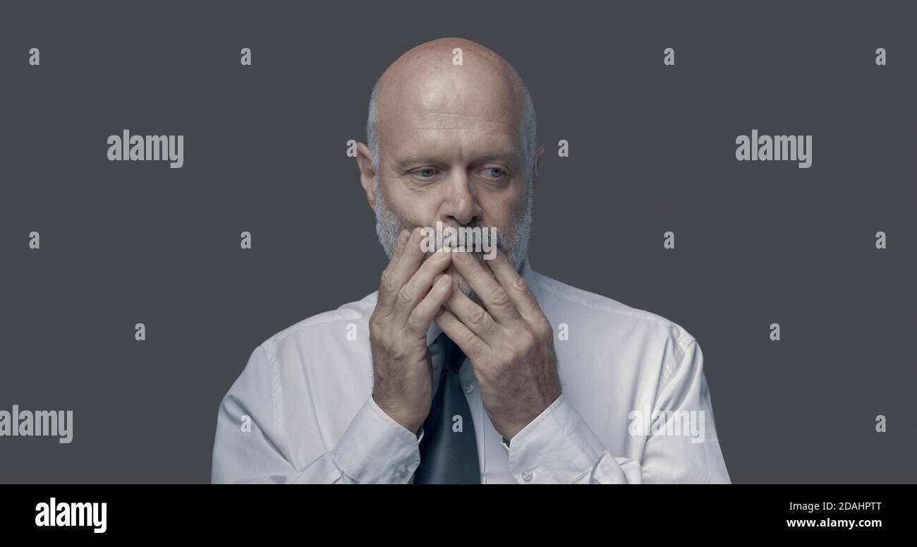 Confused middle-aged businessman thinking and looking away, he is ...