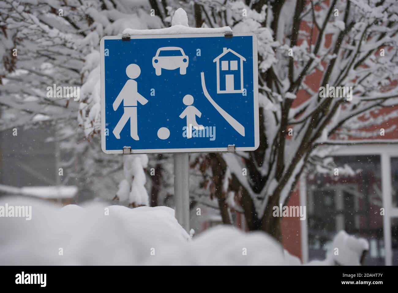 blue residential street sign, drive slow, snowed in sign in winter ...